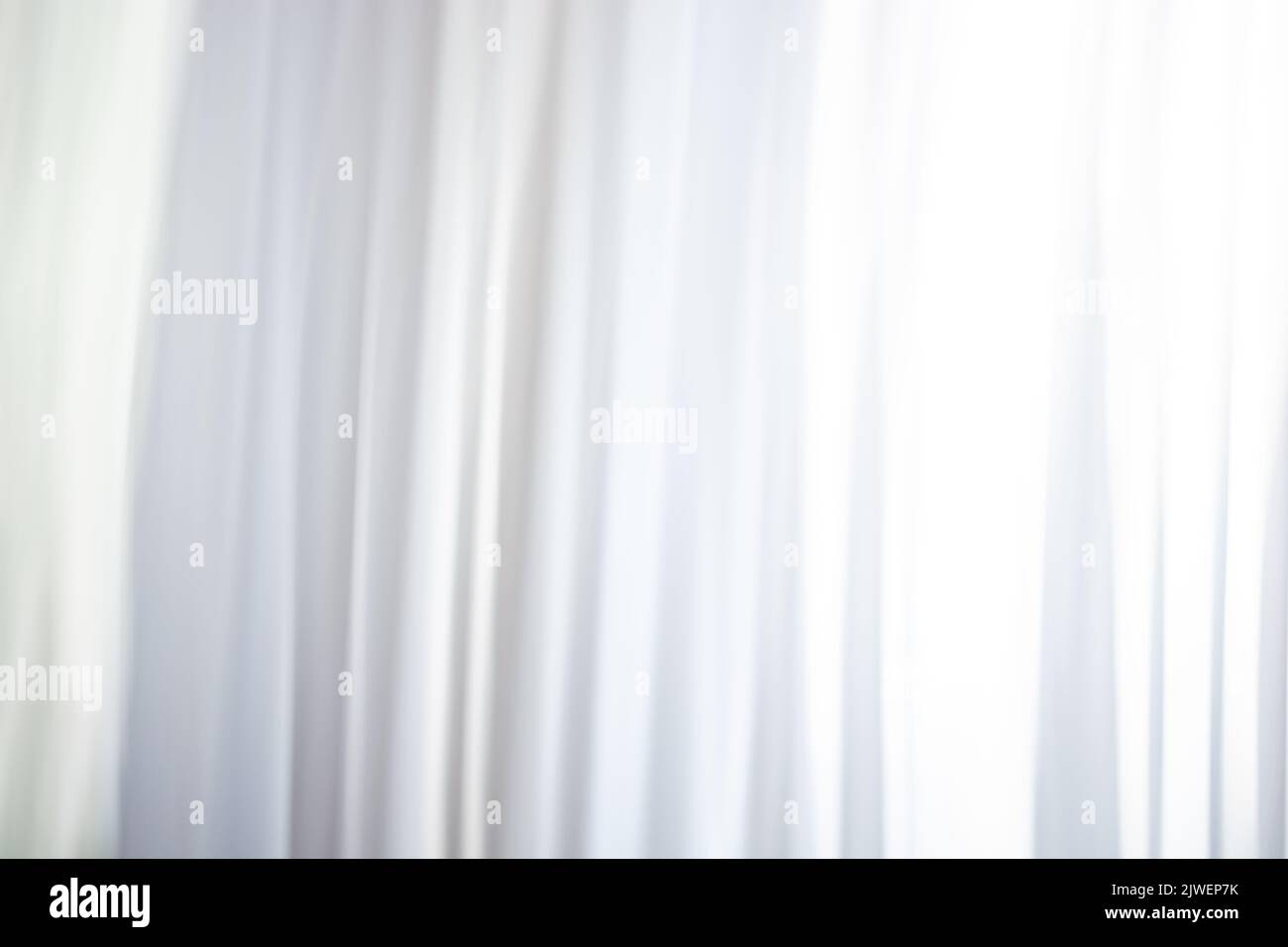 Background of white curtains with a gleam from the window, waves and ...