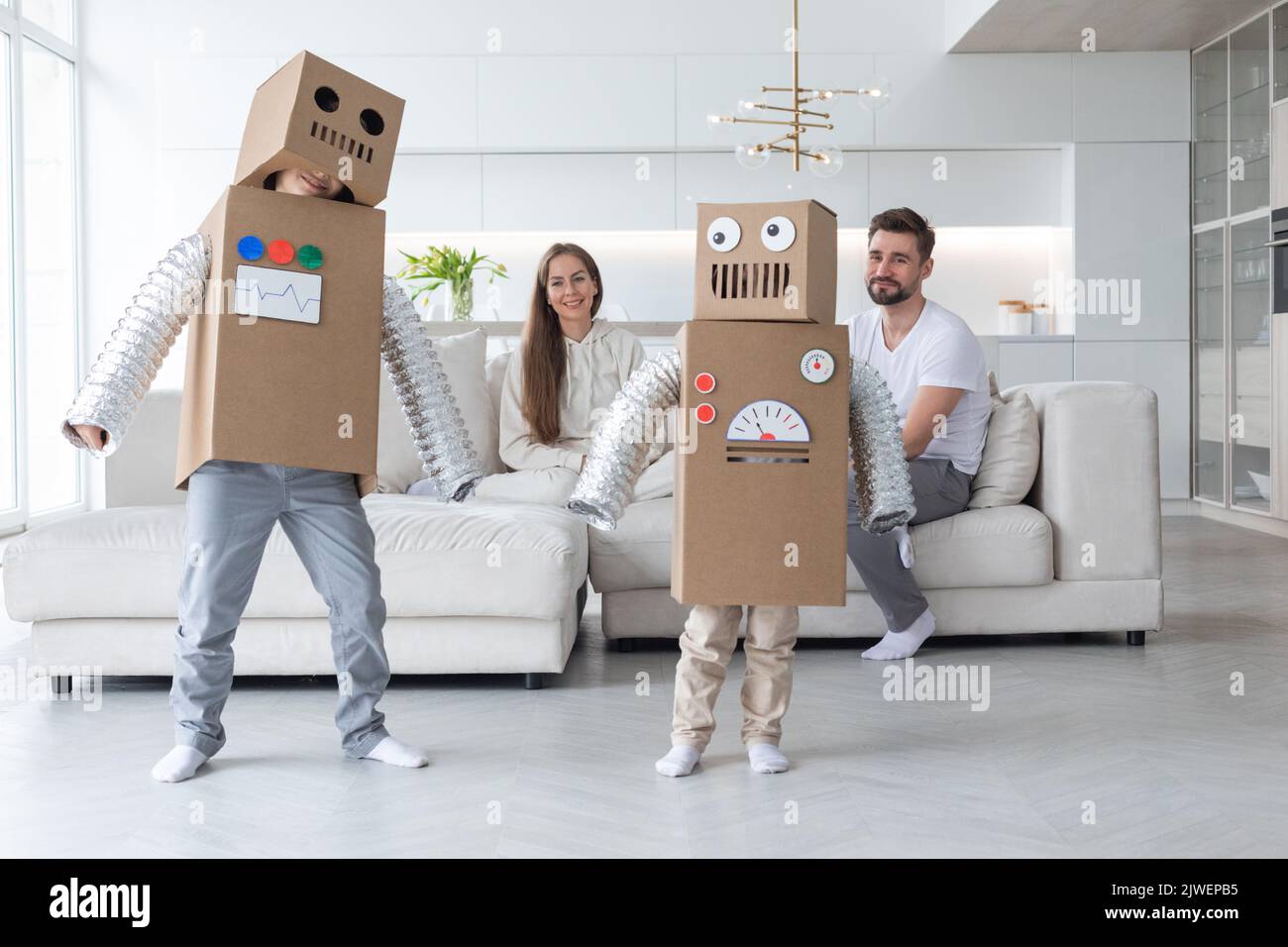 Happy family of parents and two children playing dancing like robots at ...
