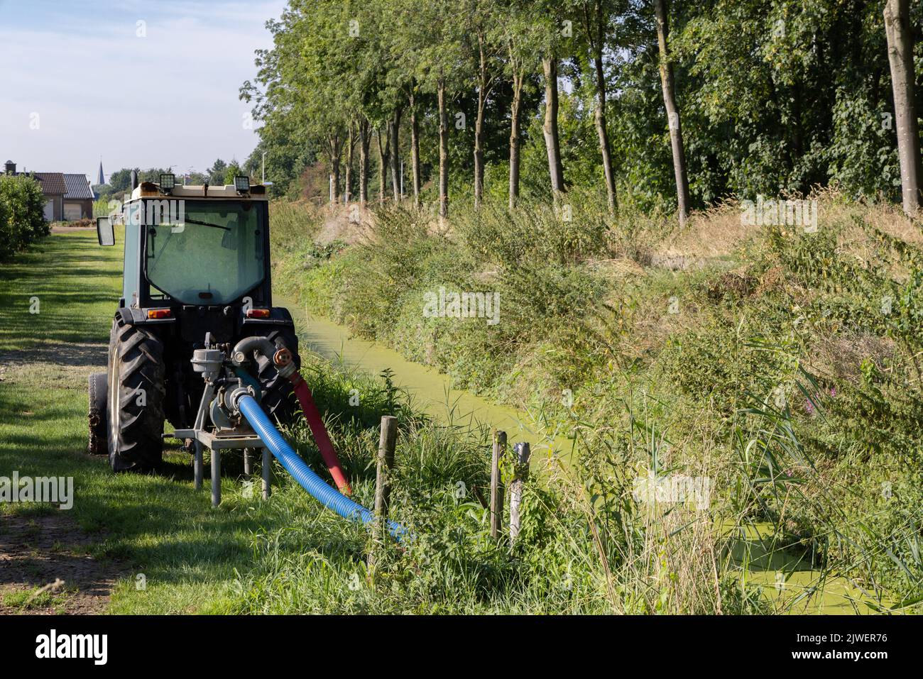 Small tractor with water pump pumps water from ditch for spraying the ...