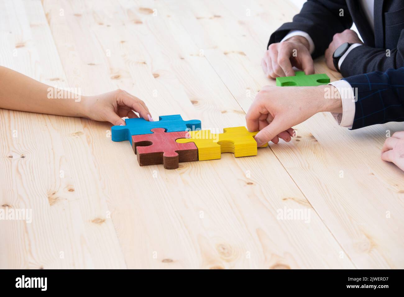 Business people helping in assembling puzzle, cooperation in decision ...