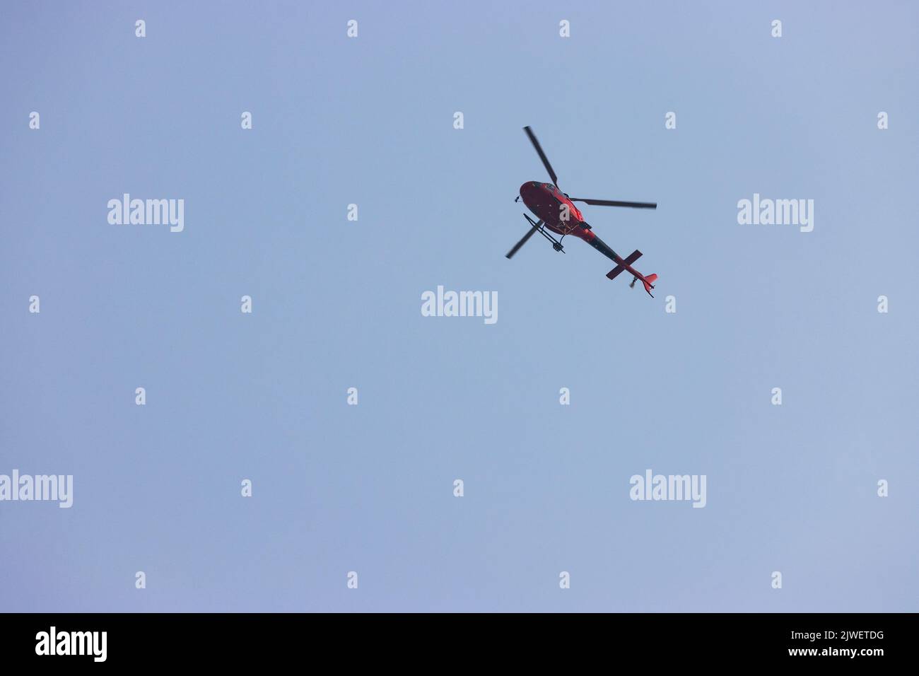 helicopter flying overhead in blue sky Stock Photo - Alamy