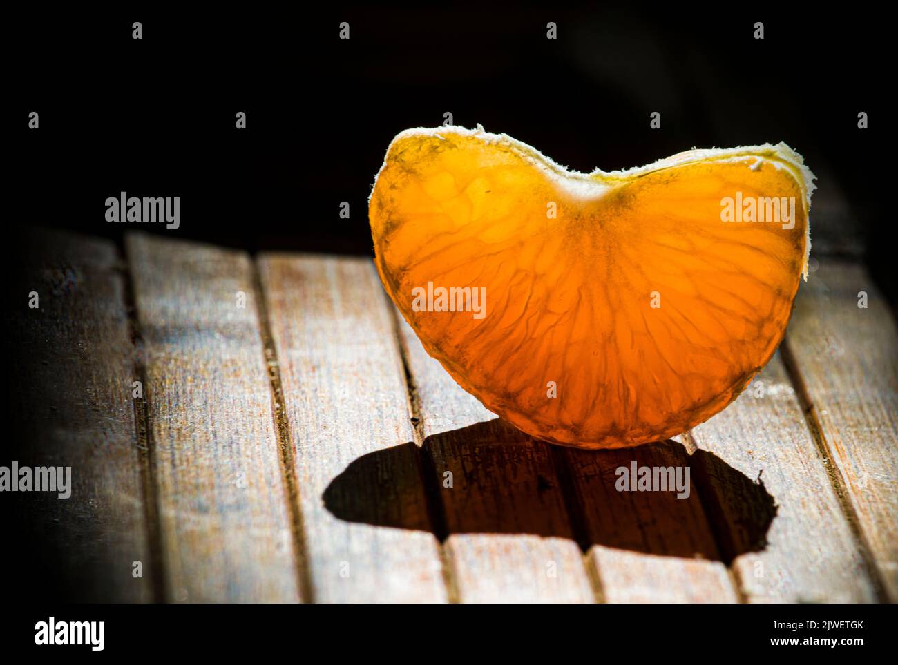 A slice of tangerine in contrast light Stock Photo - Alamy