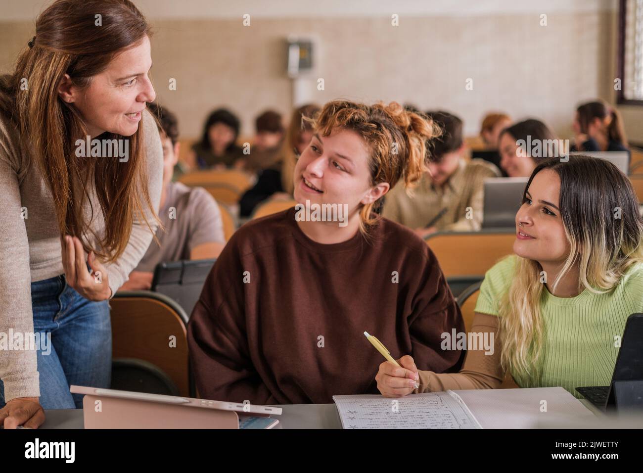 Teacher explaining individually to her students at the university Stock ...