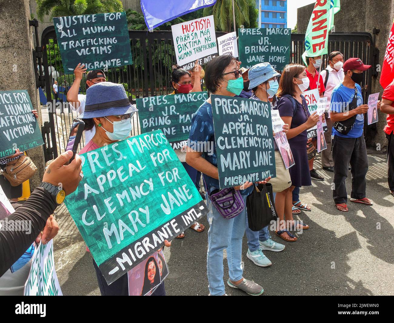Protesters hold placards during a prayer rally at the gate of the ...