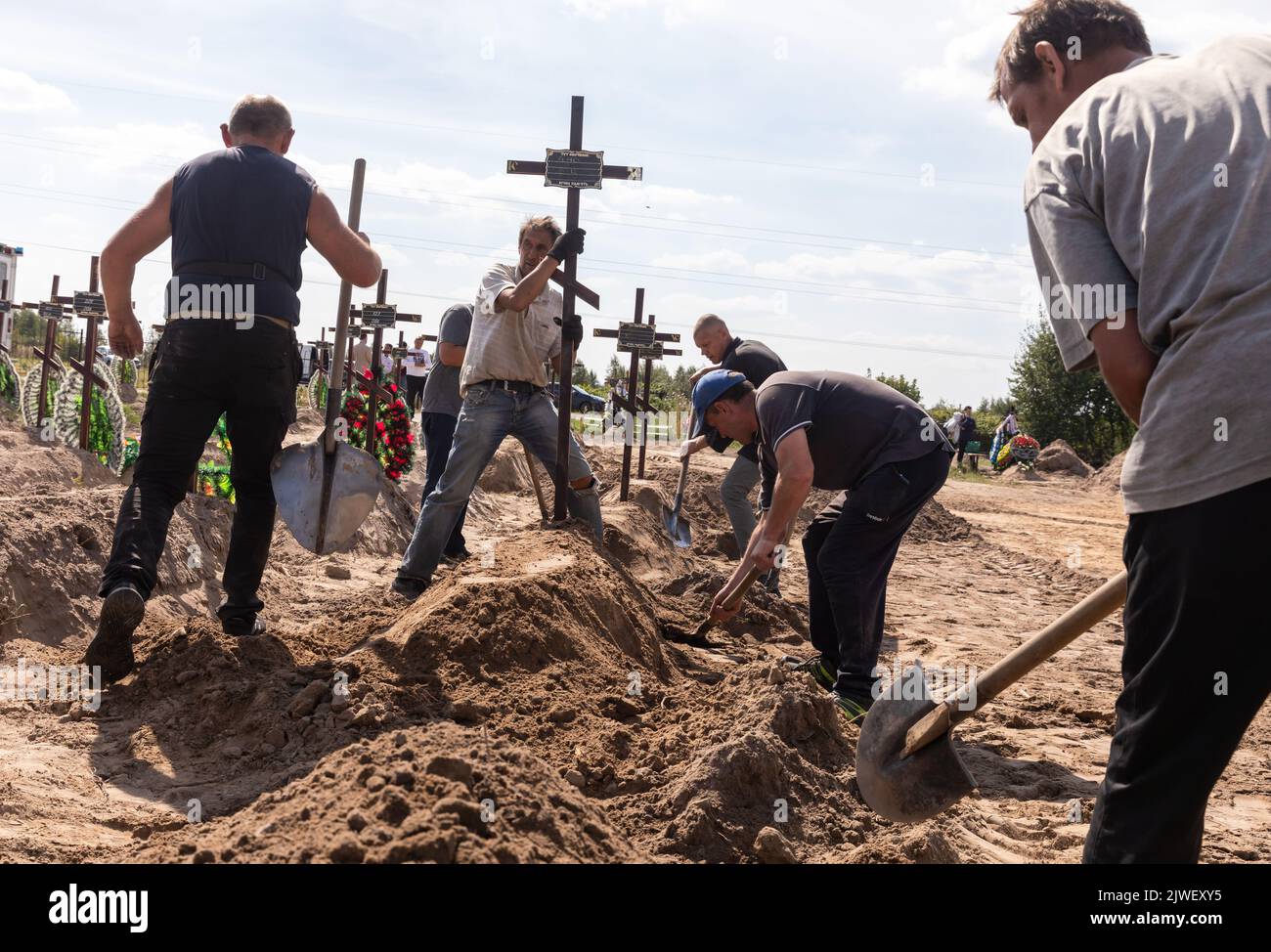 A group of men bury unidentified victims of Russian aggression at the ...