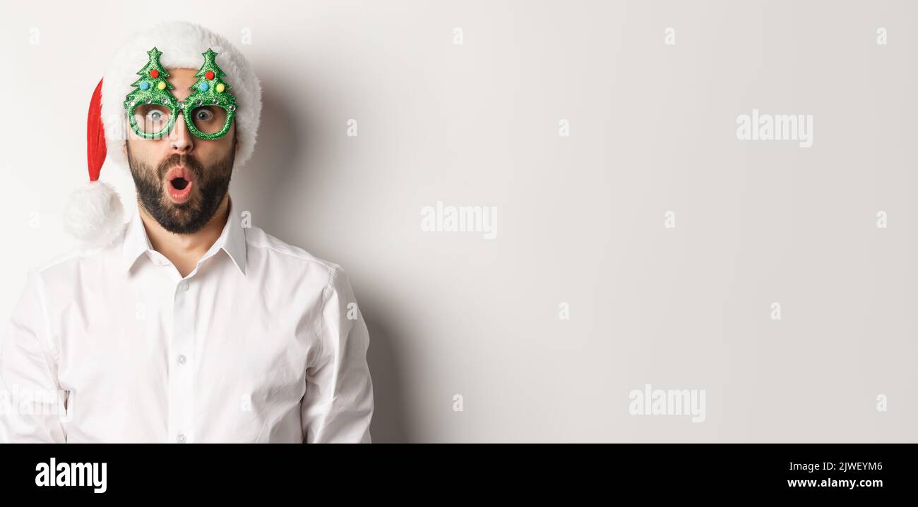 Adult man celebrating winter holidays, wearing christmas party glasses ...