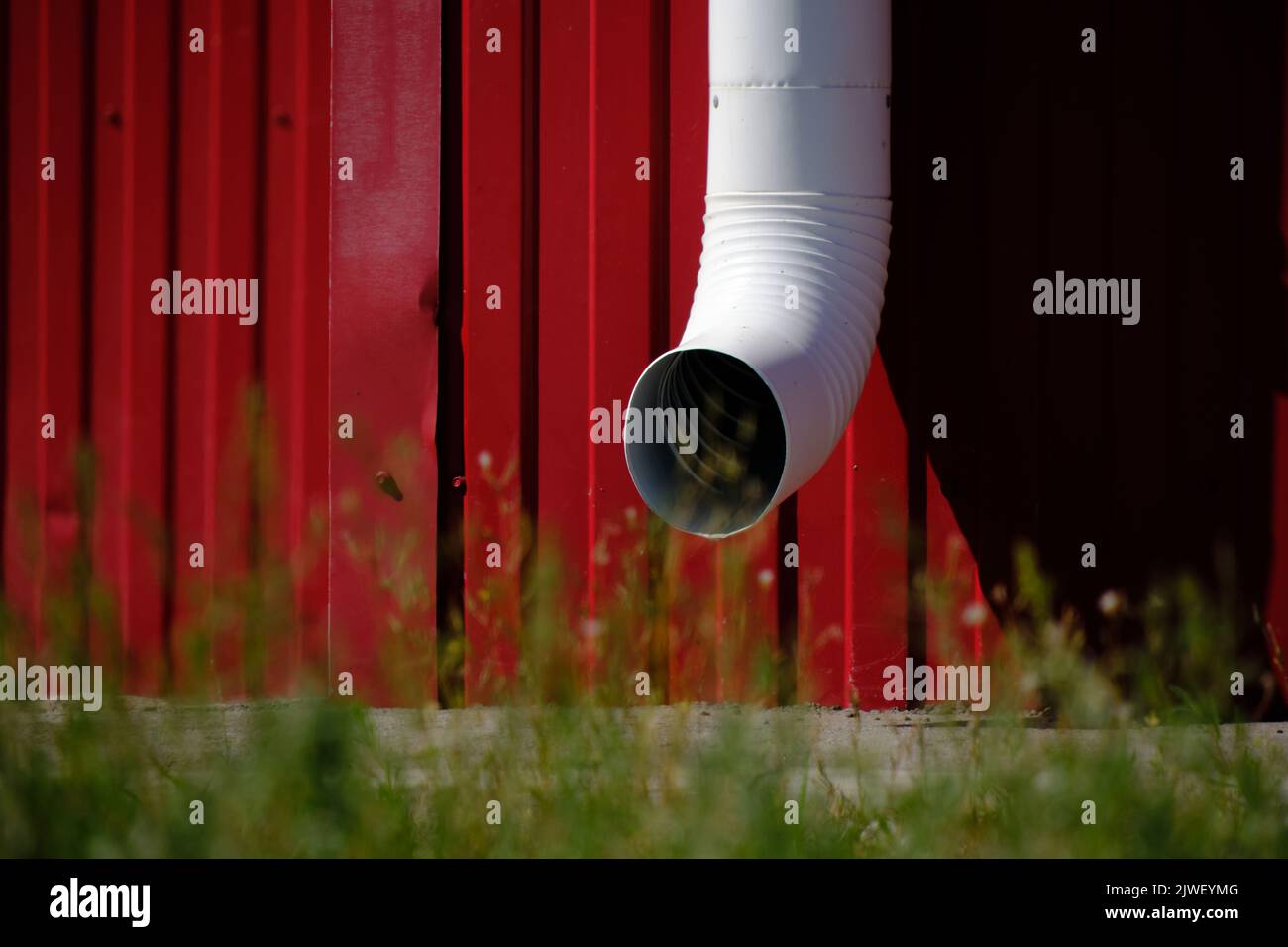 Rainwater drain pipe background red wall Stock Photo - Alamy