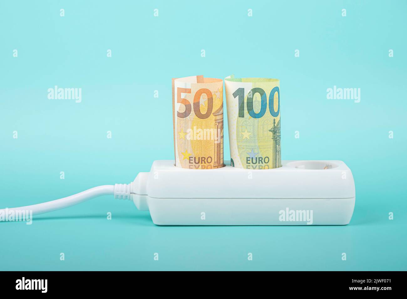 Euro money banknotes plugged in power strip extension cord on light ...