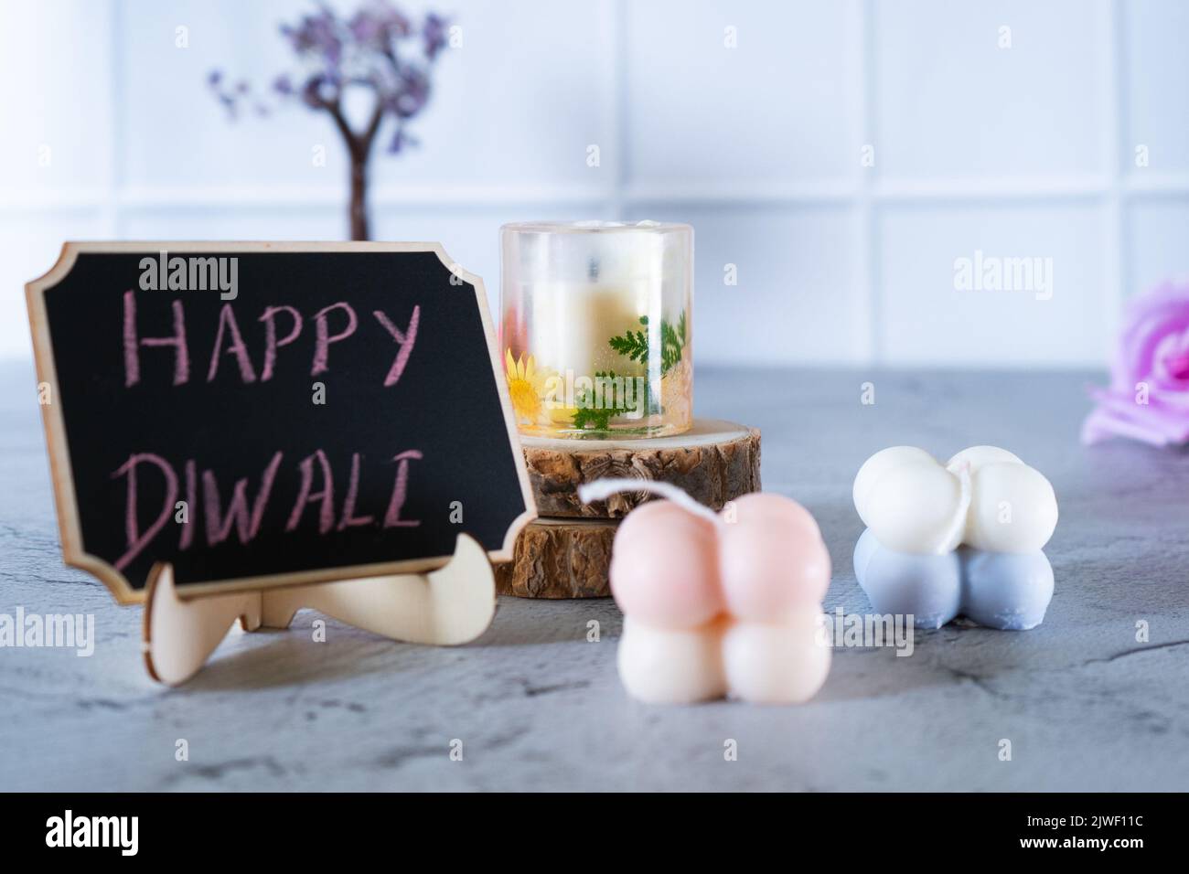 small bubble candles and blackboard with happy diwali written in chalk ...