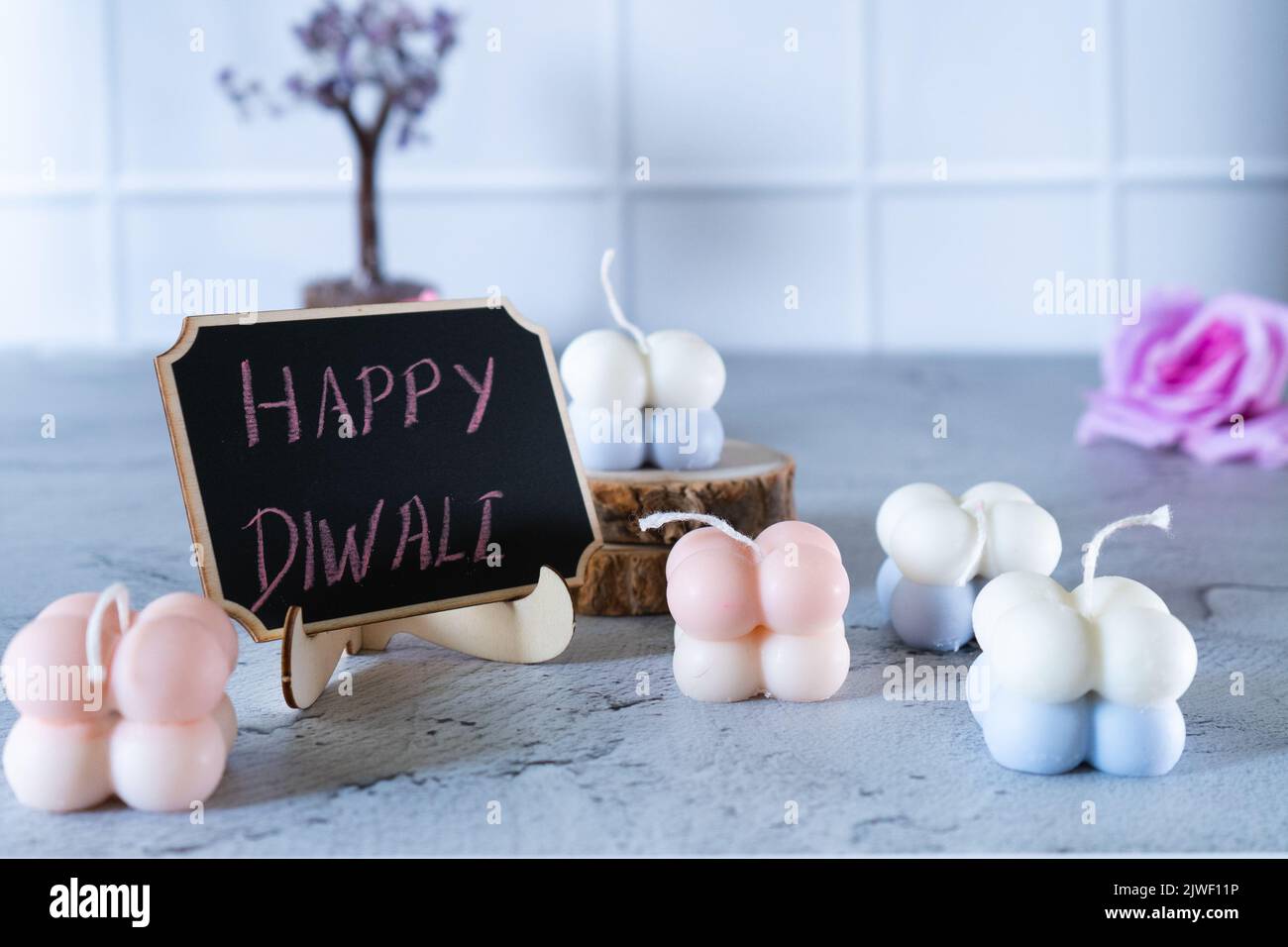 small bubble candles and blackboard with happy diwali written in chalk ...