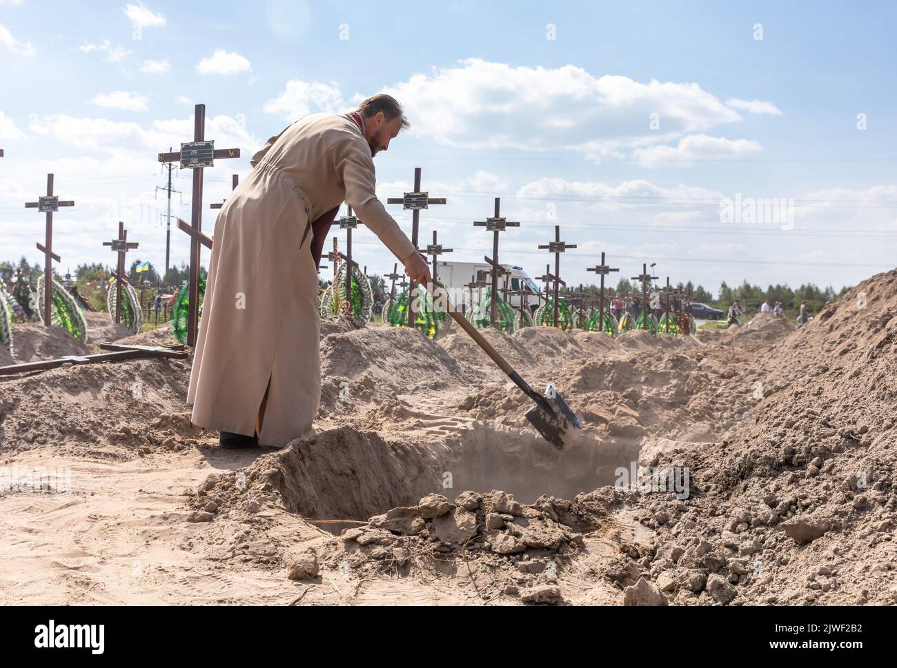 Bucha, Ukraine. 2nd Sep, 2022. A priest is seen conducting a burial ...