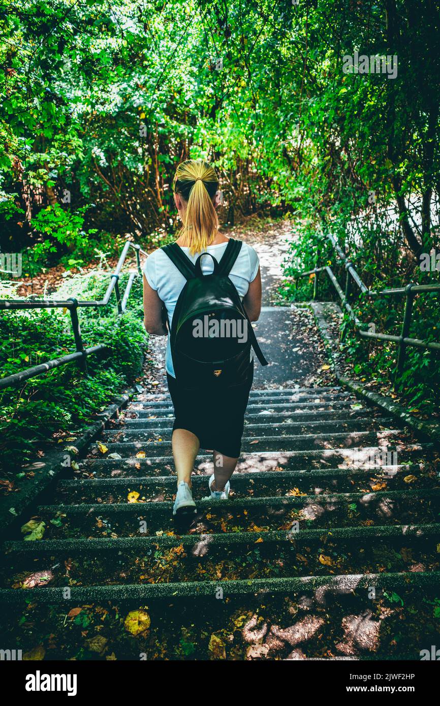 Woman walking down a set of steps (Aug22 Stock Photo - Alamy