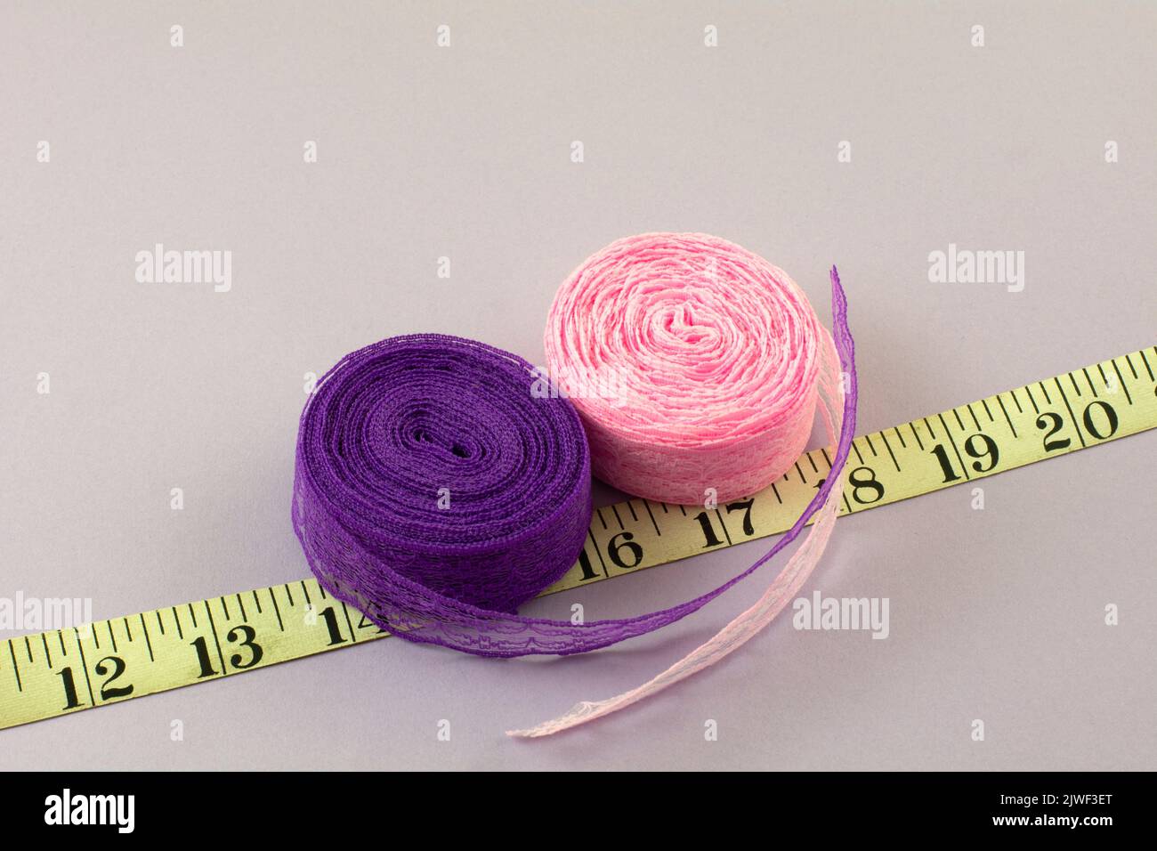 Rolls of pink and purple lace ribbons and measuring tape Stock Photo ...