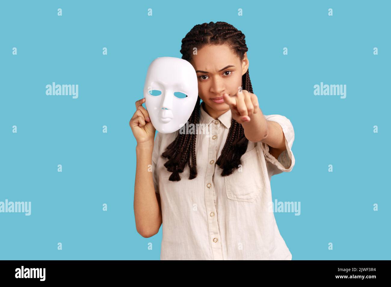 Strict bossy woman with black dreadlocks holding white mask in hand ...