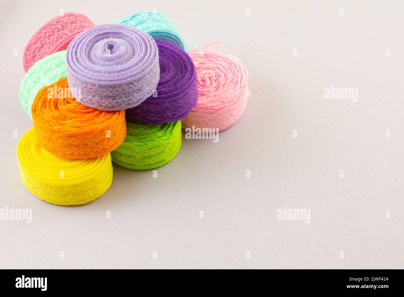 Rolls of lace ribbons in stacked up in a pile Stock Photo - Alamy