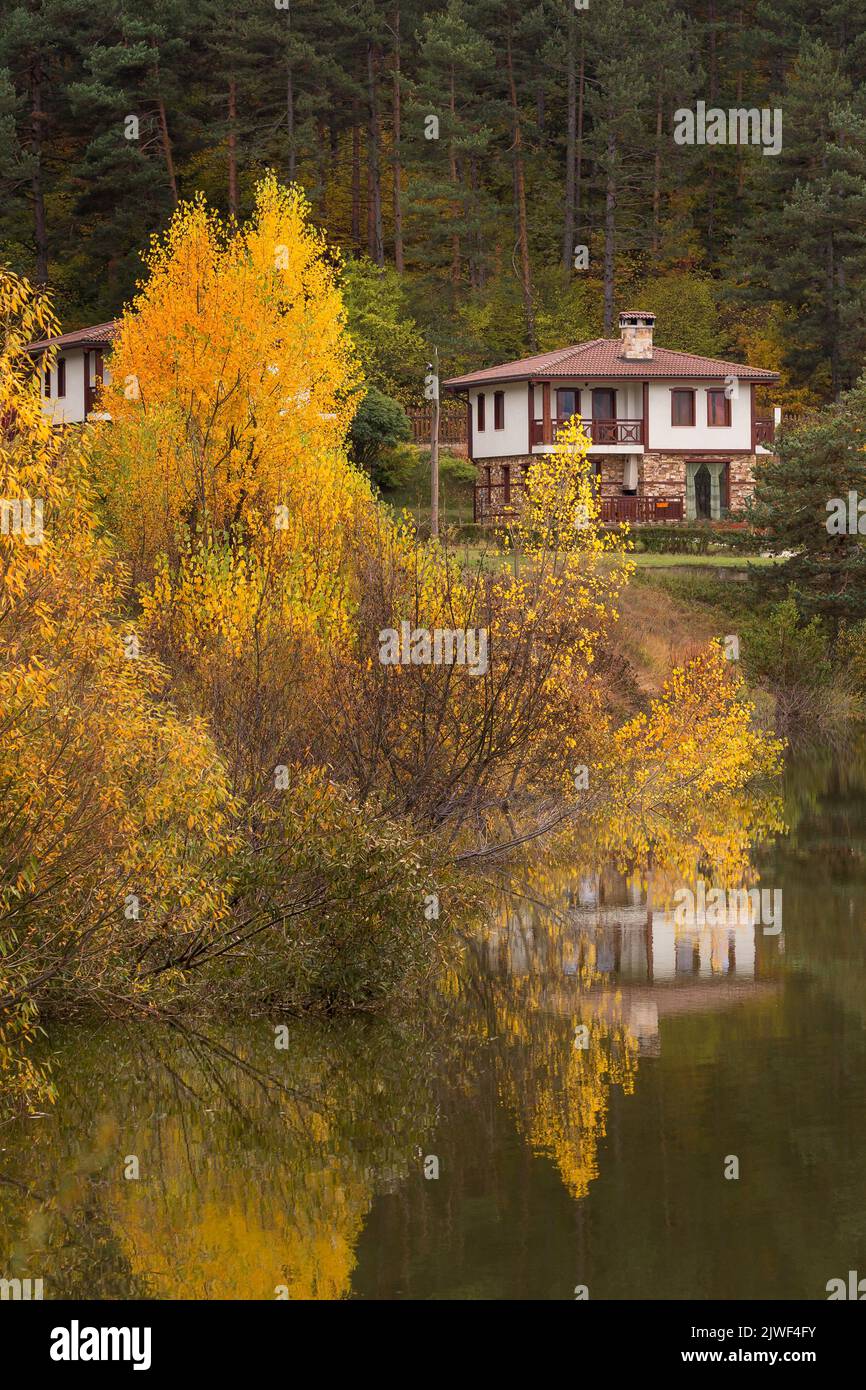 Autumn landscape with traditional bulgarian houses, lake and reflection ...