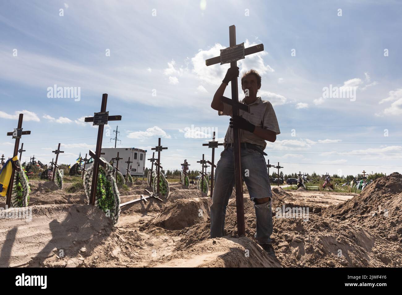 Bucha, Ukraine. 2nd Sep, 2022. A man seen placing a cross on a grave at ...