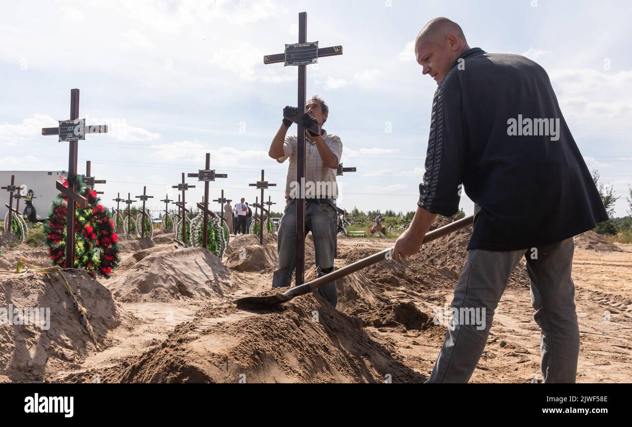 Bucha, Ukraine. 2nd Sep, 2022. A man seen placing a cross on a grave at ...