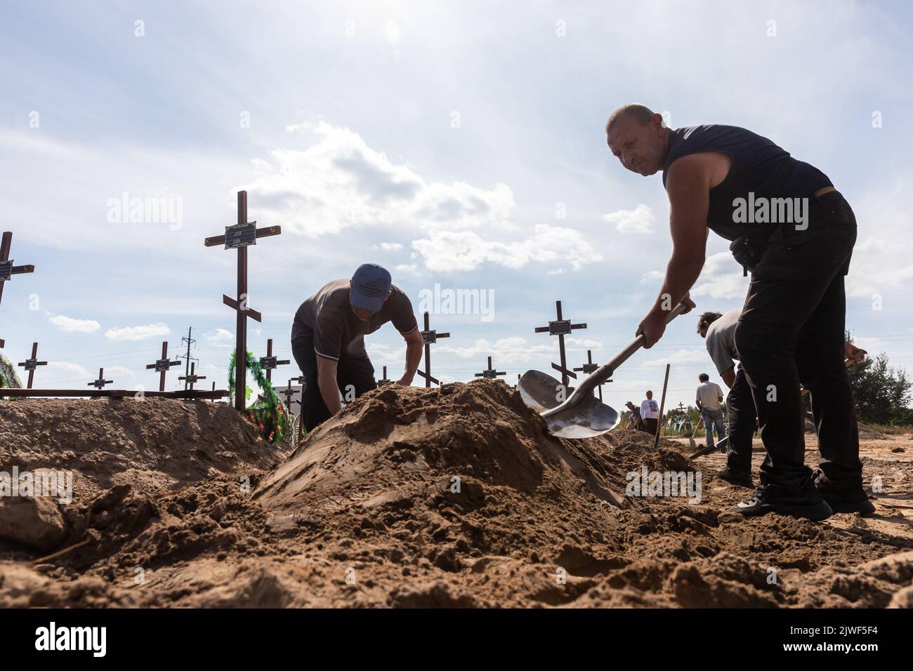 Bucha, Ukraine. 2nd Sep, 2022. A group of men bury unidentified victims ...
