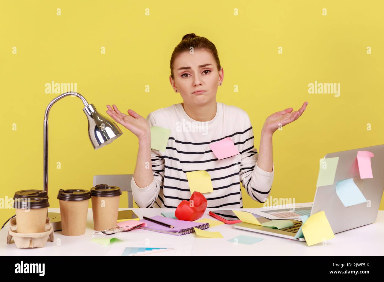 Confused woman covered with sticky notes sitting office workplace with ...