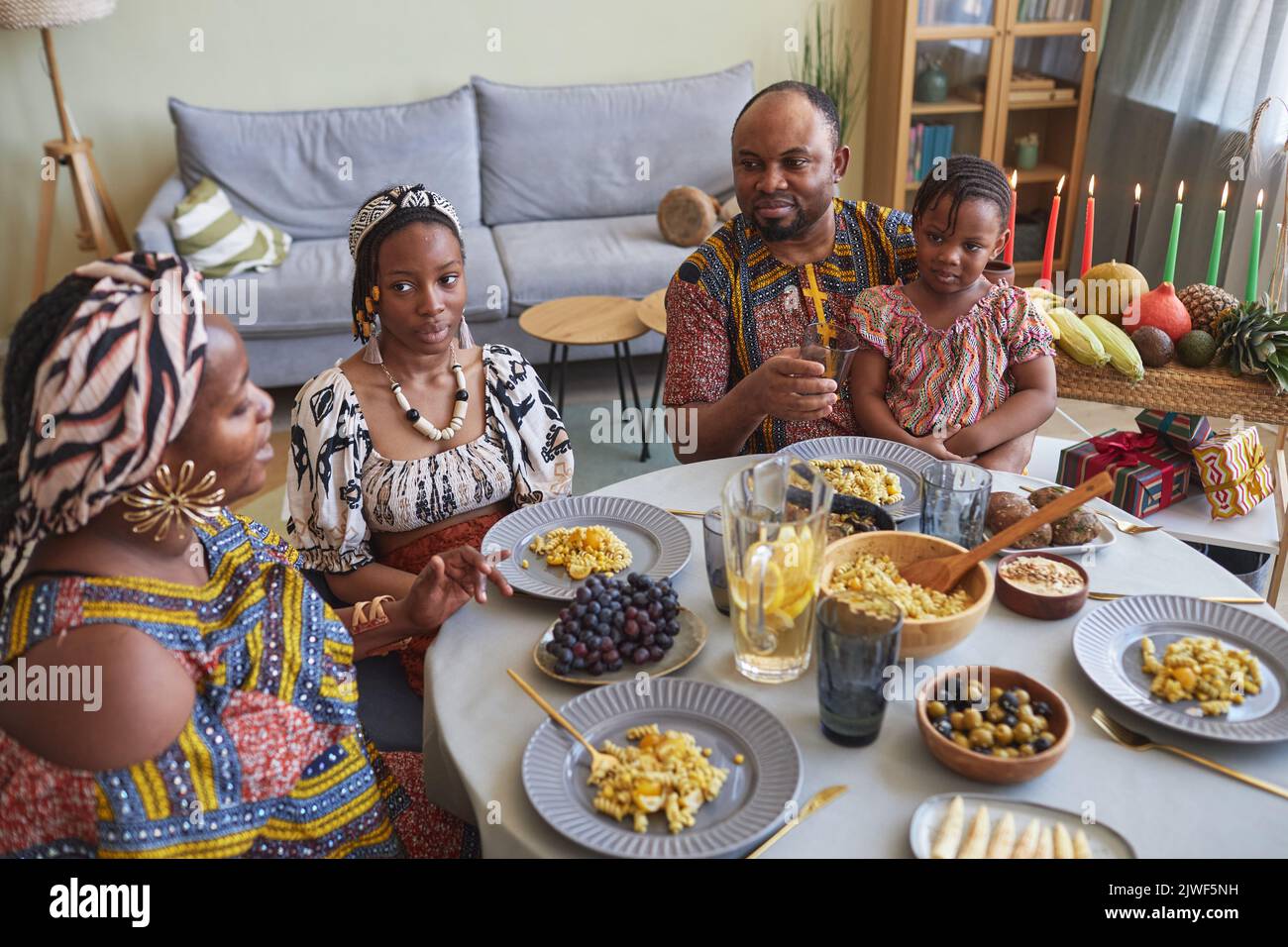 African family of four having holiday dinner at table at home, they ...