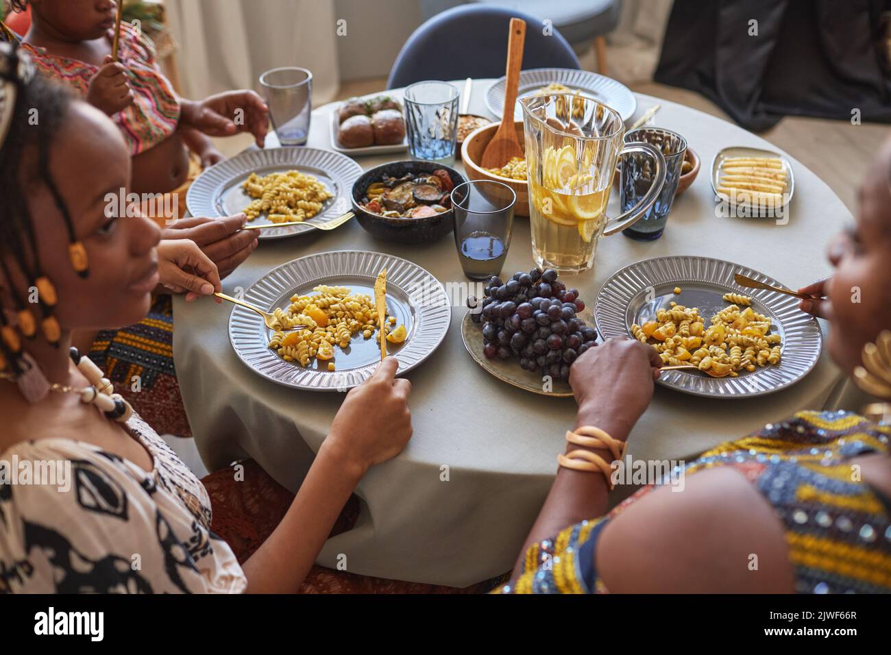 African family in traditional costumes having traditional dinner at ...