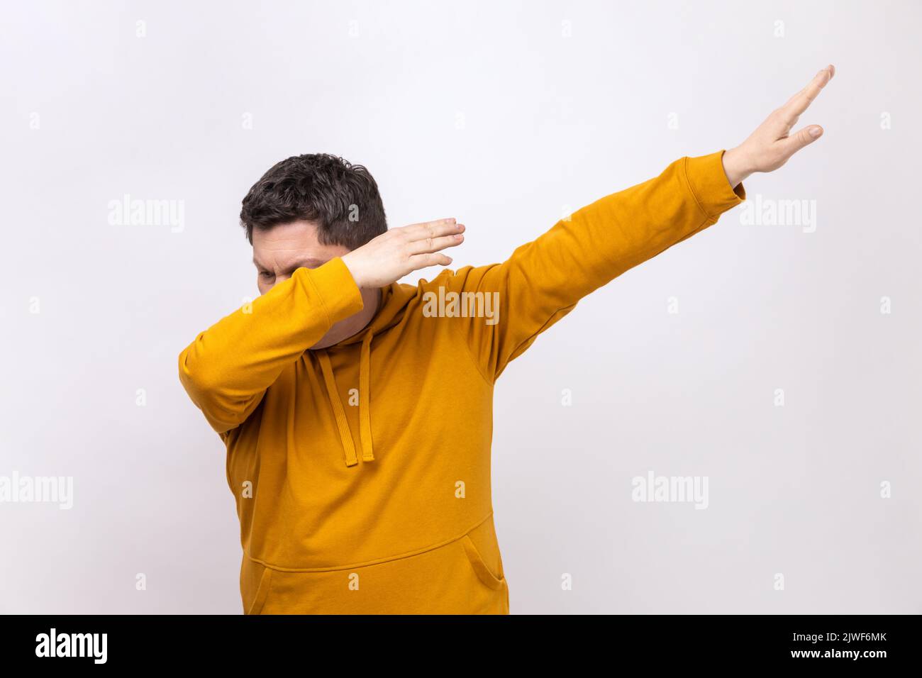 Portrait of dark haired anonymous man standing in dab dance pose ...