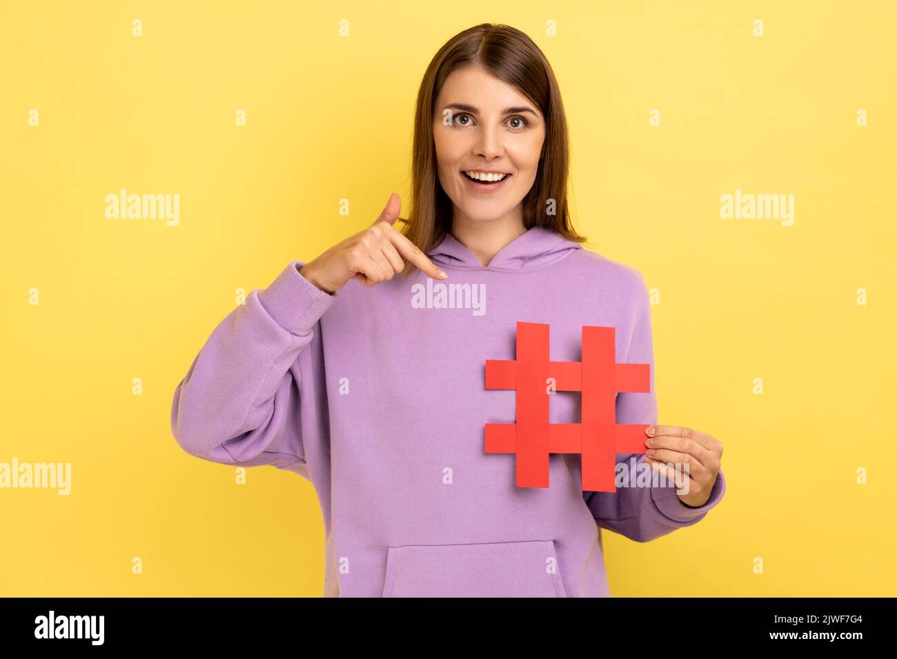 Attention to interesting blog post. Happy woman pointing at red hashtag ...