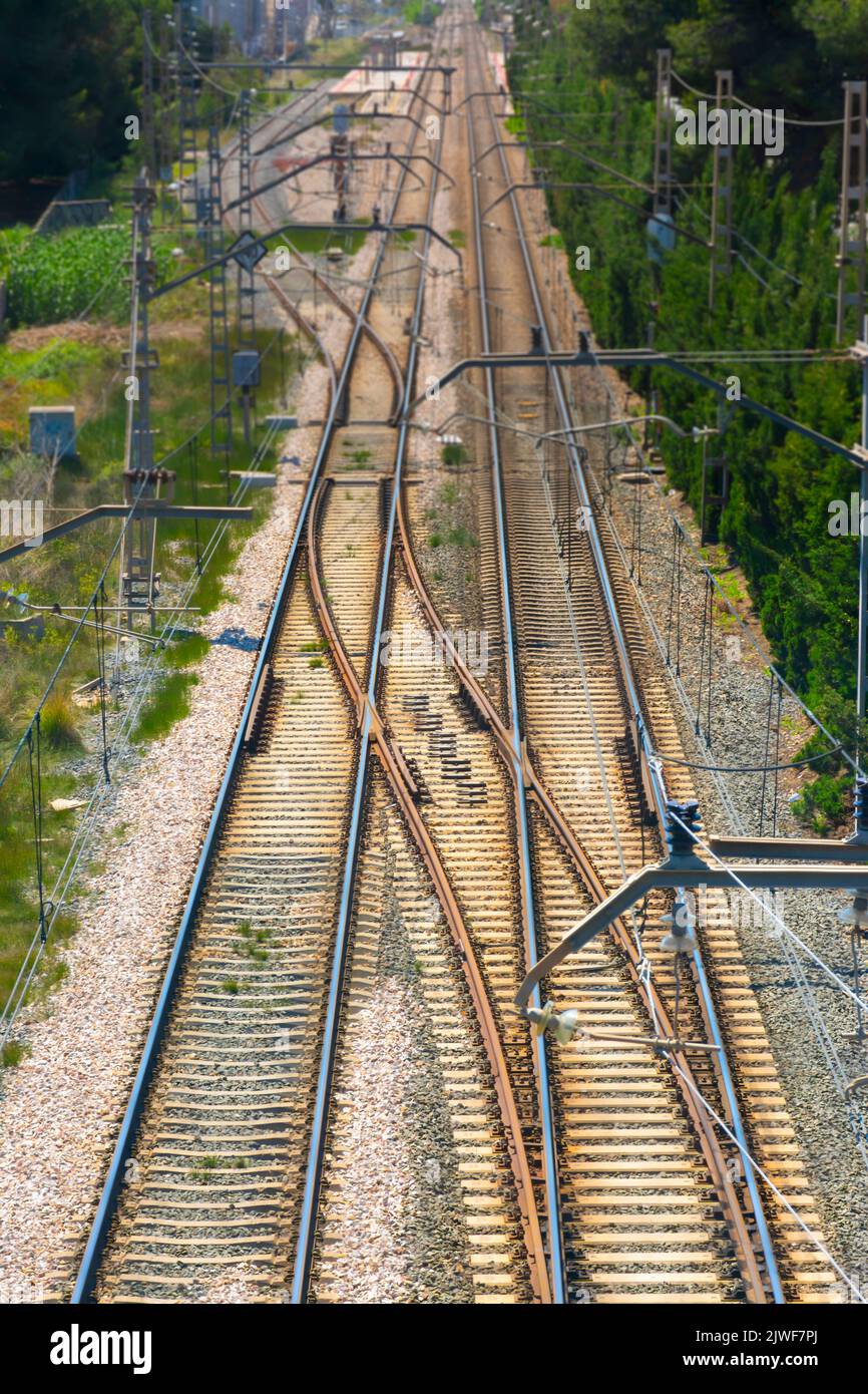 Straight train tracks with rail change, with a platform in the ...