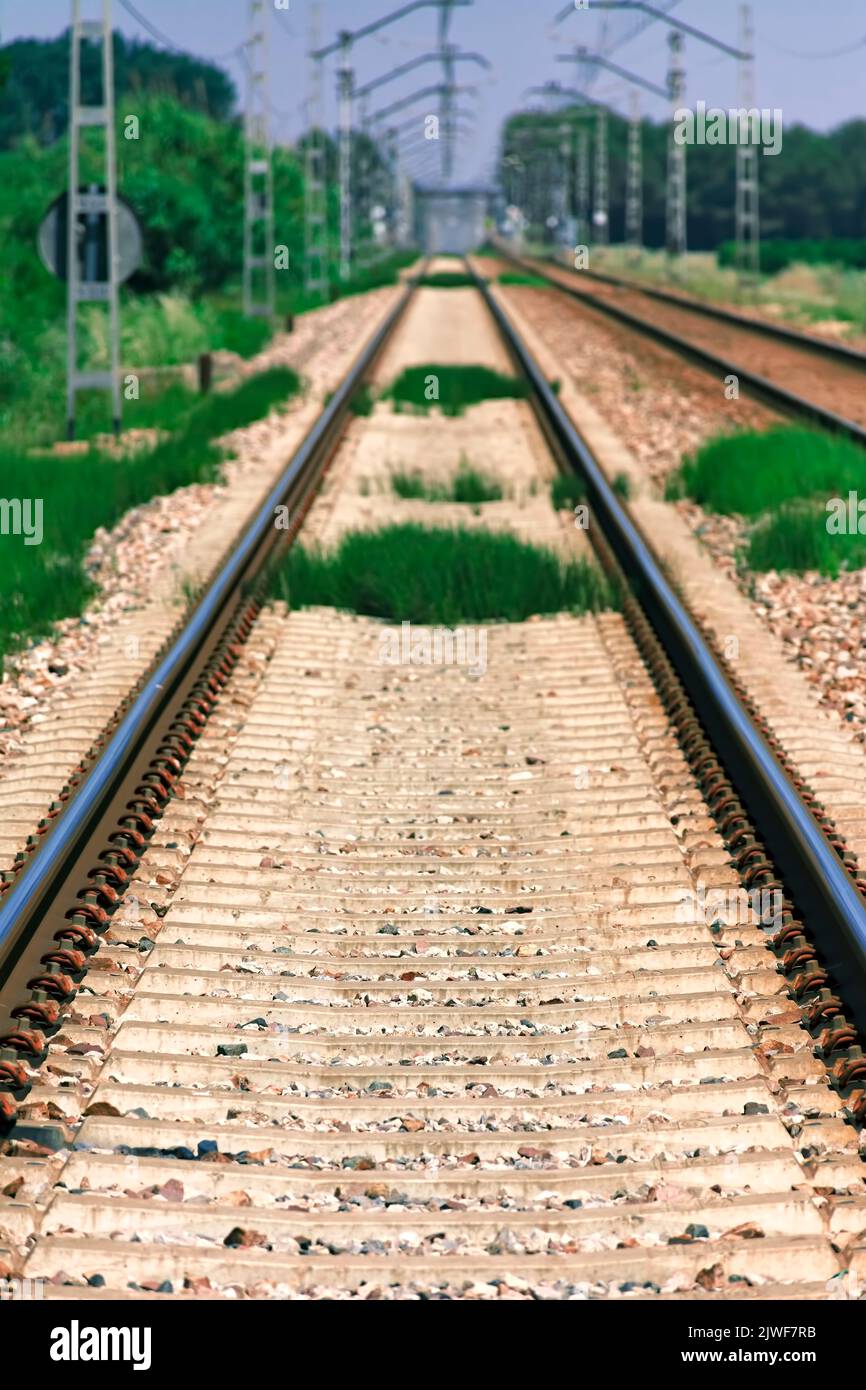 Straight train tracks in perspective into the distance, with selective ...