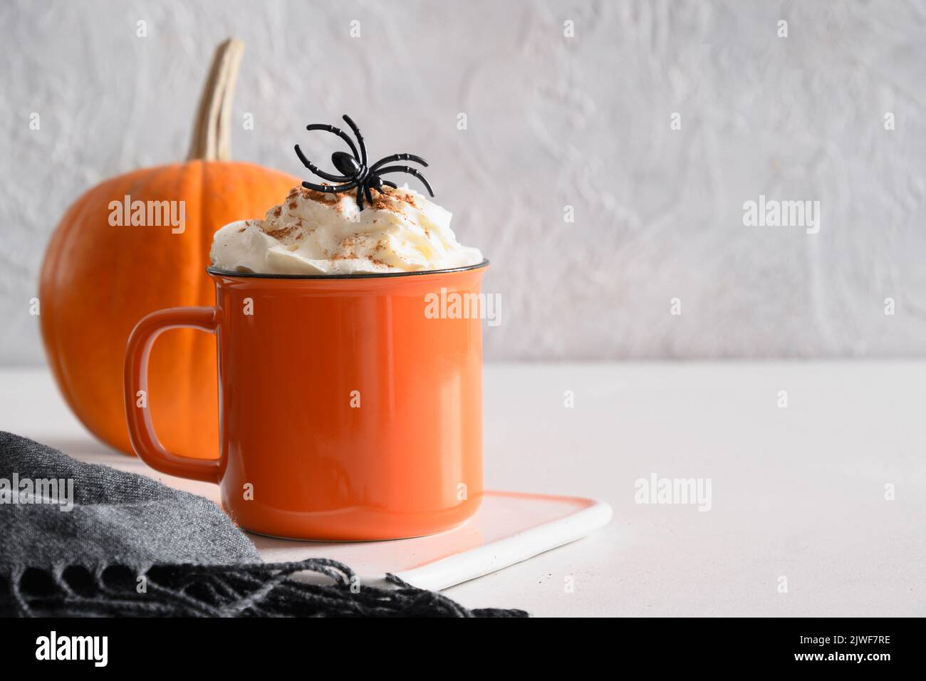 Halloween pumpkin latte coffee with whipped cream decorated spiders on ...