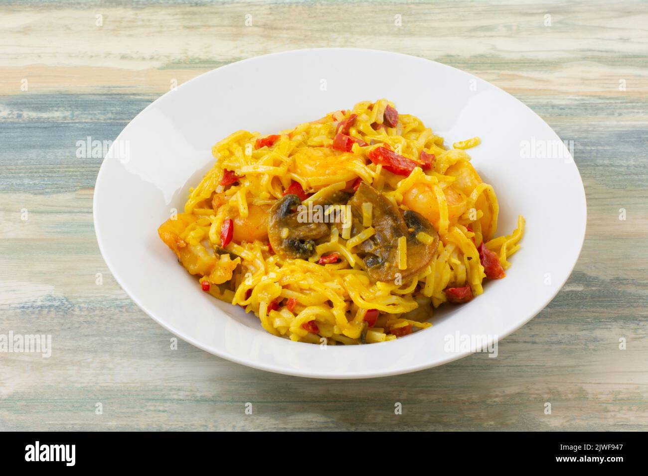 Curry shrimp pasta with mushrooms and red bell peppers dinner in white ...