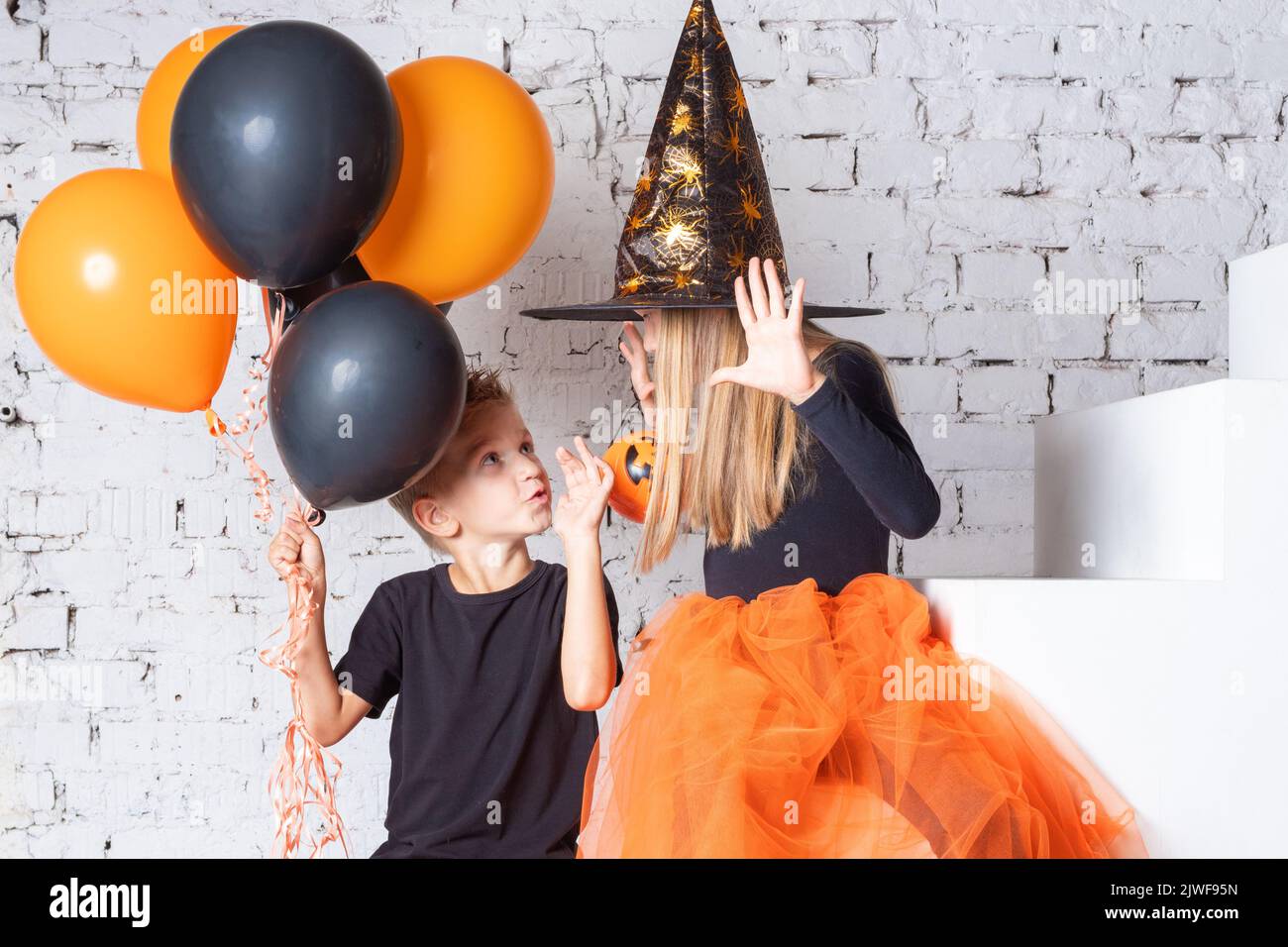 Kids on Halloween. A little girl and a boy in witch and sorcerer ...