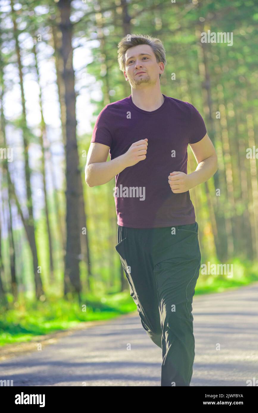 Running man jogging in city park at beautiful summer day. Sport fitness ...