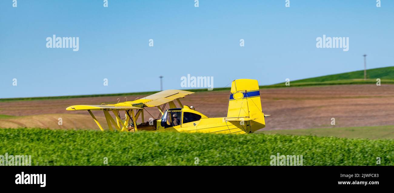 Path of a crop duster takes it below farm field horizon Stock Photo - Alamy