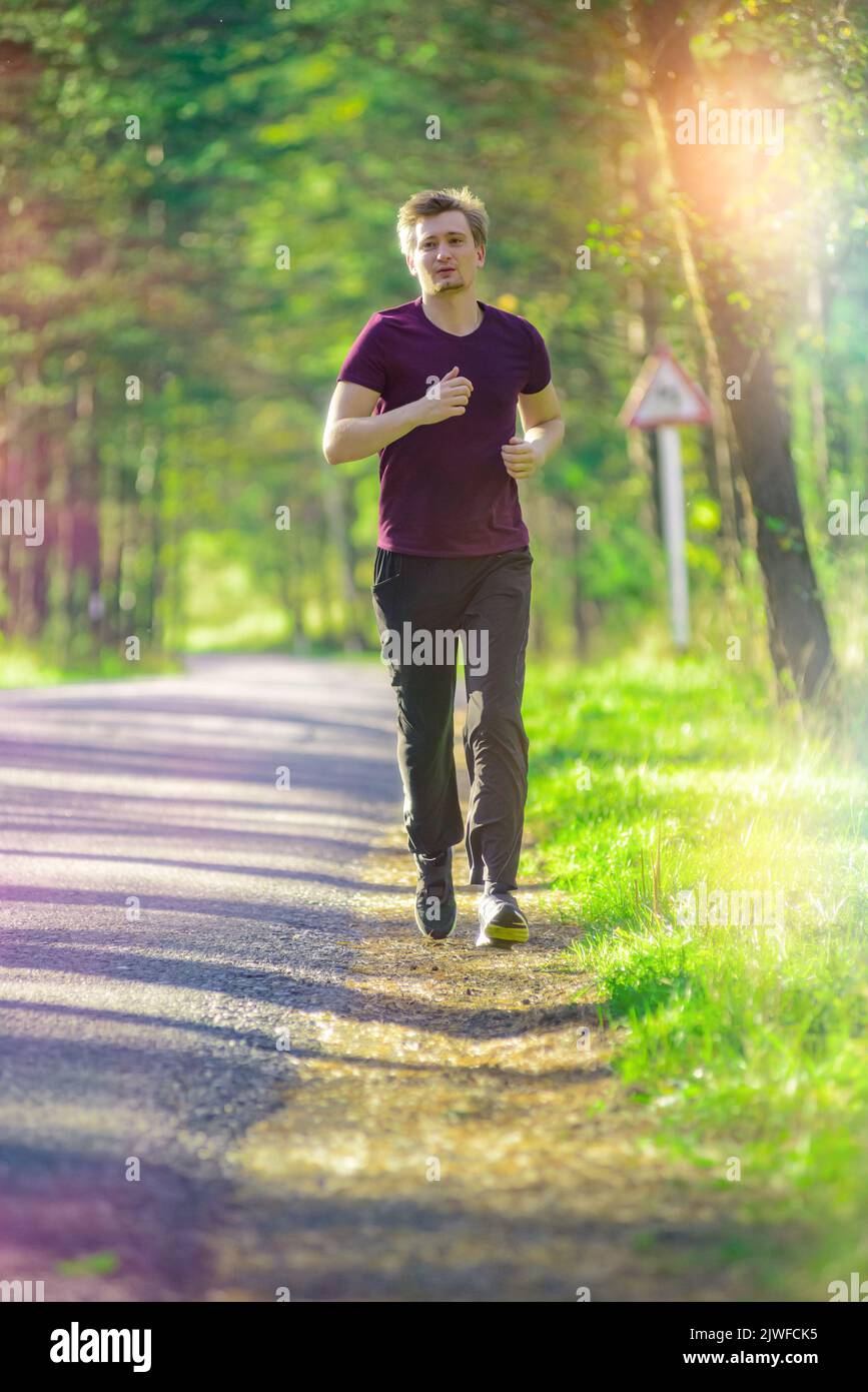Running man jogging in city park at beautiful summer day. Sport fitness ...
