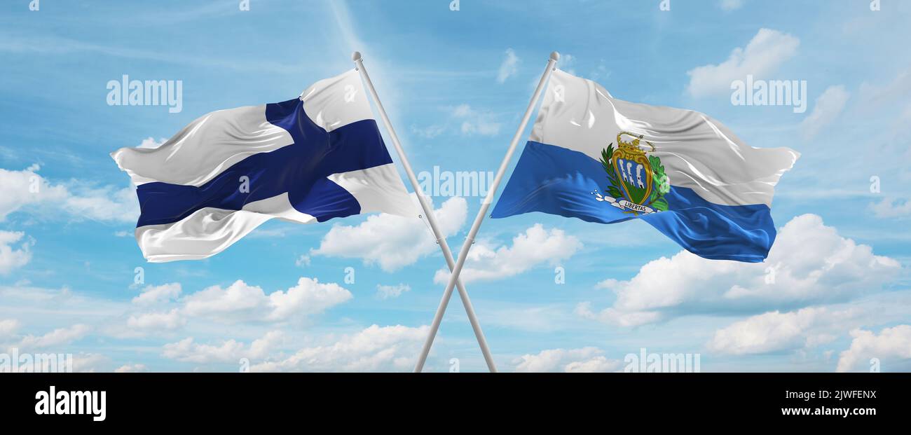 two crossed flags San Marino and finland waving in wind at cloudy sky ...