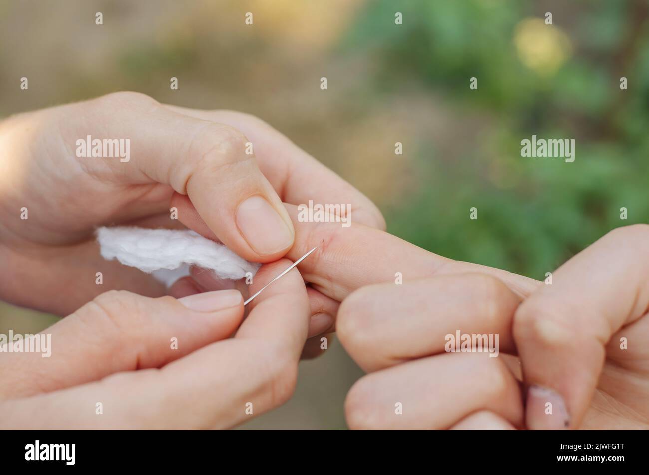 The woman is trying to pull the splinter out of the child's hand. A ...