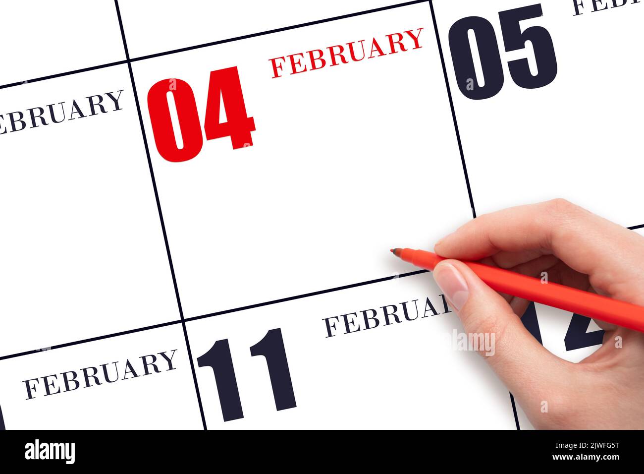 4th day of February. A hand holding a red pen and pointing on the ...