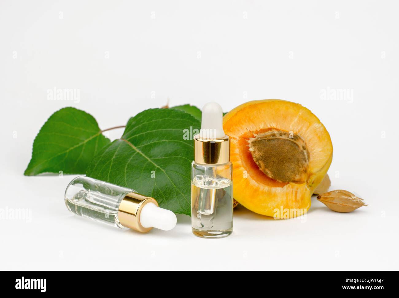 Transparent bottle with apricot essential oil and fresh apricot fruit ...