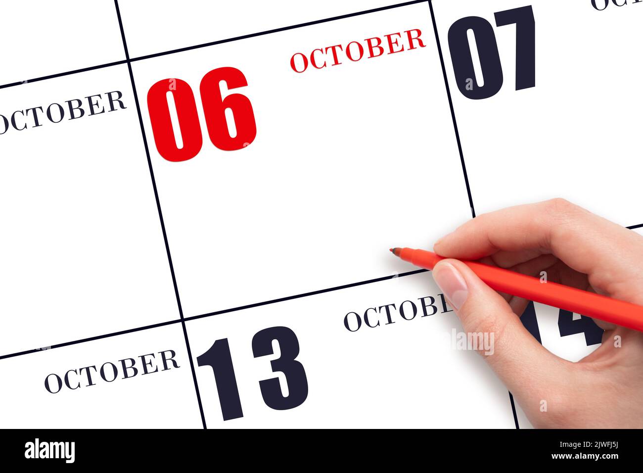 6th day of October. A hand holding a red pen and pointing on the ...