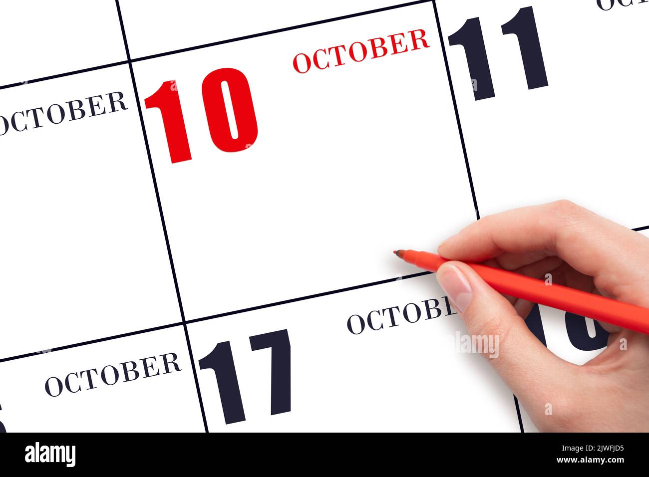 10th day of October. A hand holding a red pen and pointing on the ...