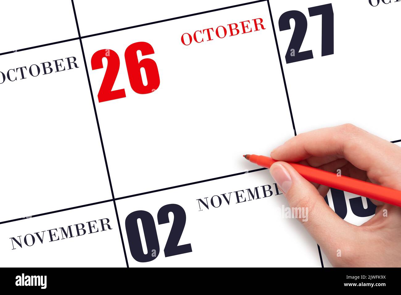 26th day of October. A hand holding a red pen and pointing on the ...