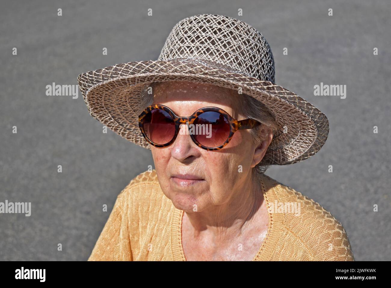 Senior old woman sunbathing on the street Stock Photo - Alamy