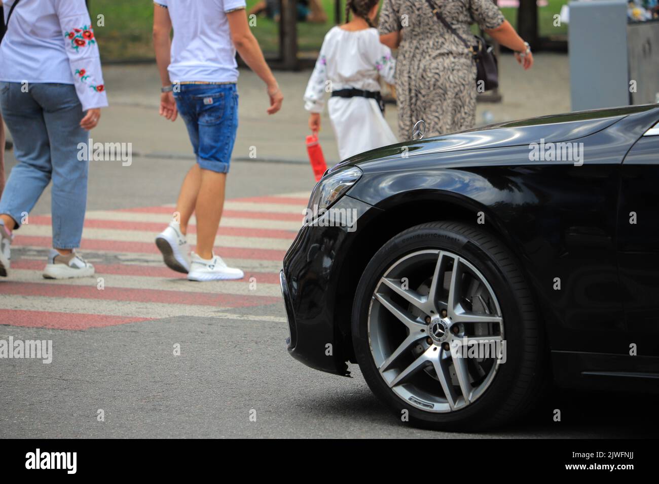 Car Mercedes-Benz passes people on a pedestrian crossing Stock Photo ...