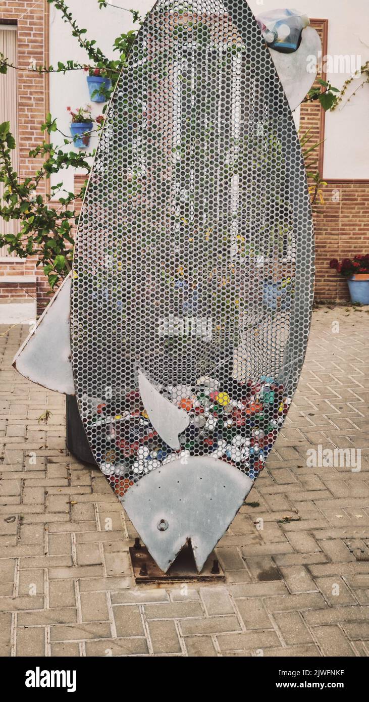 A vertical of a metallic recycling bin in the shape of a fish for ...