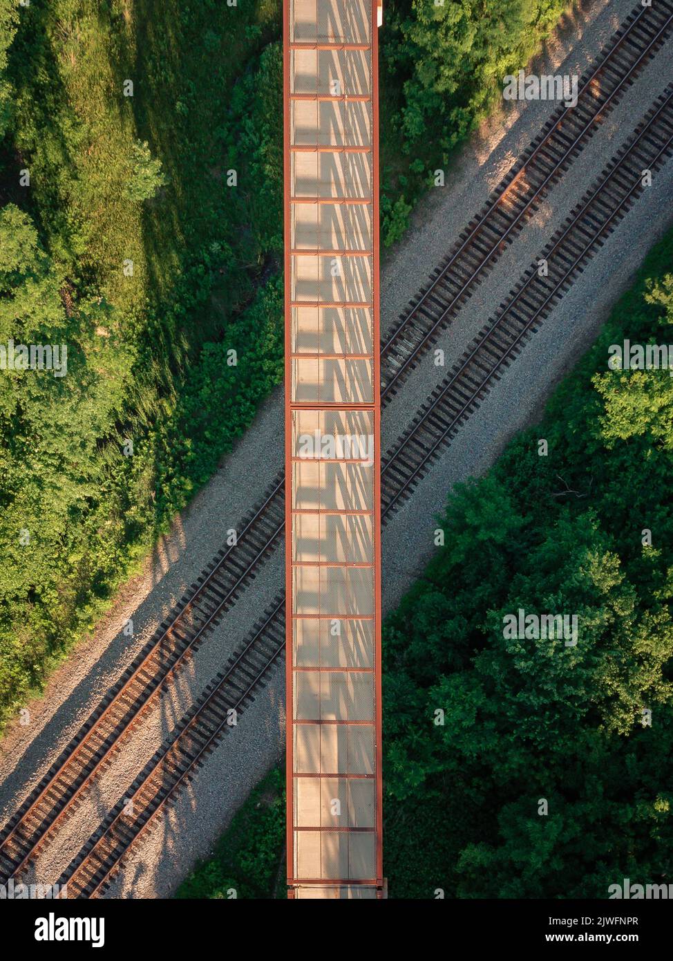A vertical aerial view of a bridge hanging above train tracks inside a ...