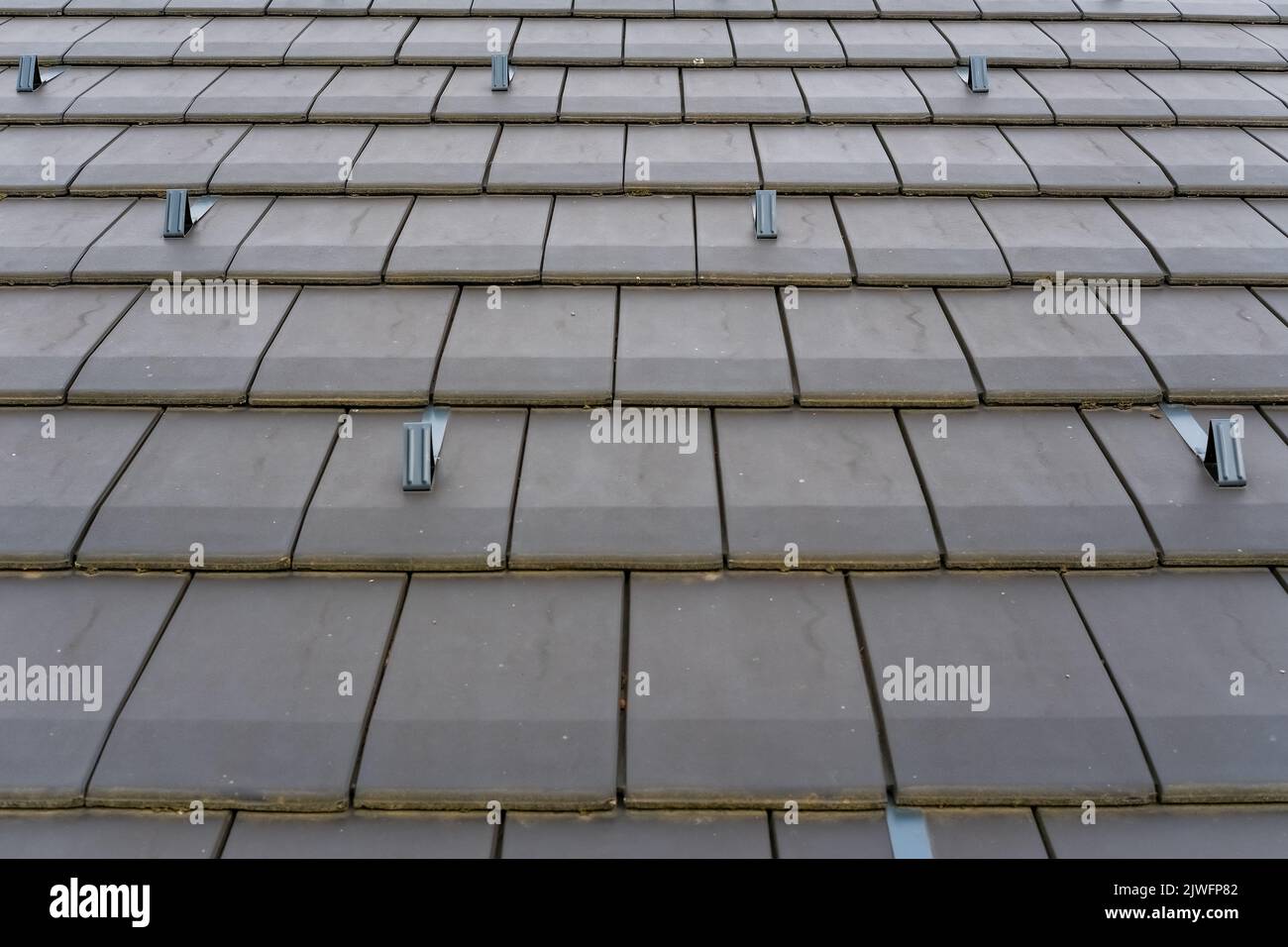 Roof with modern tiles and snow fasteners Stock Photo - Alamy