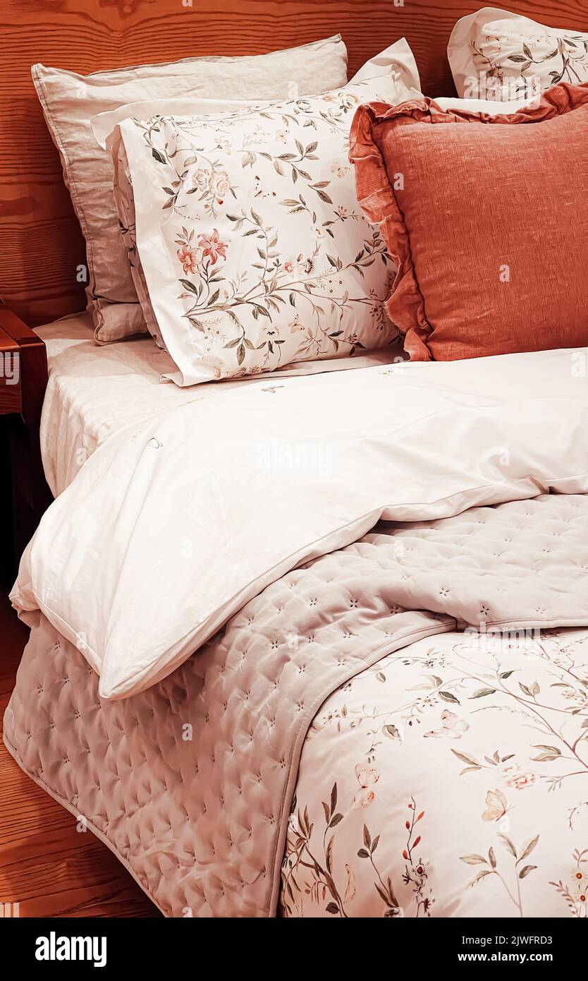 Vintage countryside style bedding with floral pattern on wooden bed in ...