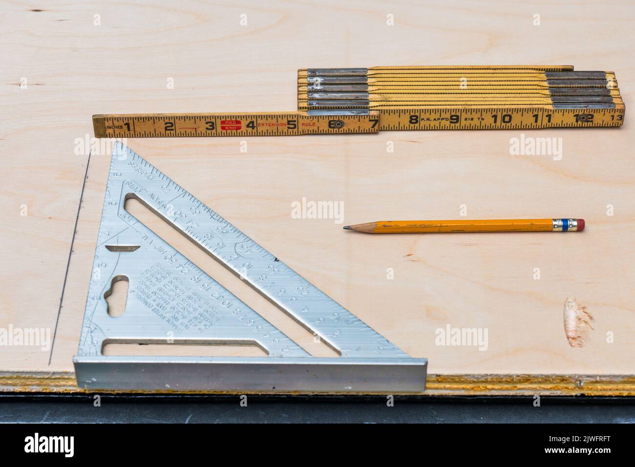 Measuring with a wooden Folding ruler and a rafter square marking with ...